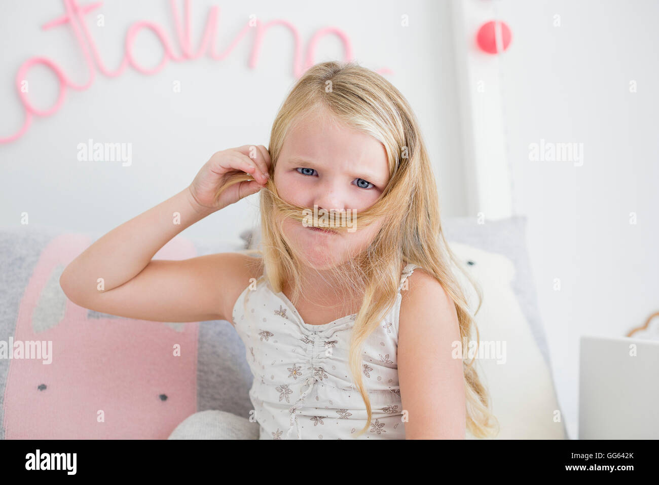 Portrait of a little girl making mustache with her hair Stock Photo - Alamy