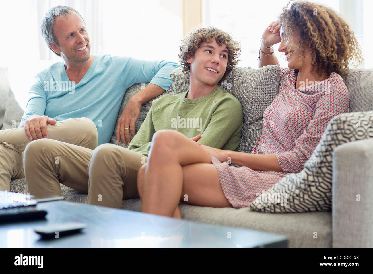 Happy family talking in a living room at home Stock Photo - Alamy