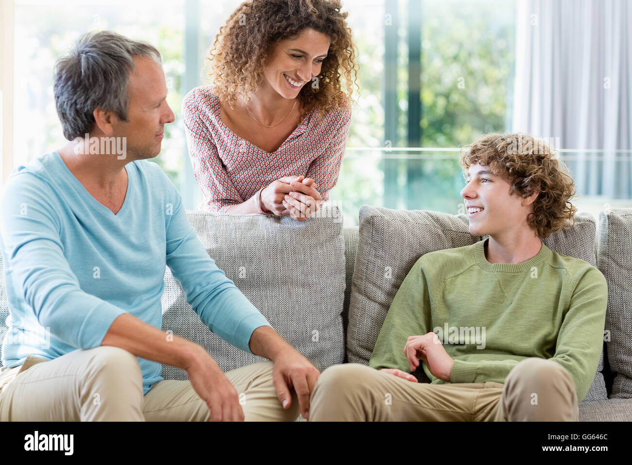 Happy family smiling in a living room at home Stock Photo - Alamy