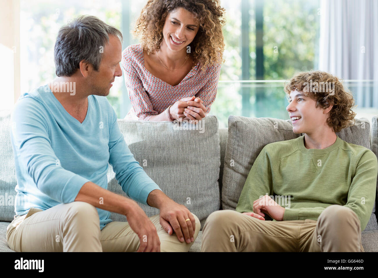 Happy family smiling in a living room at home Stock Photo - Alamy