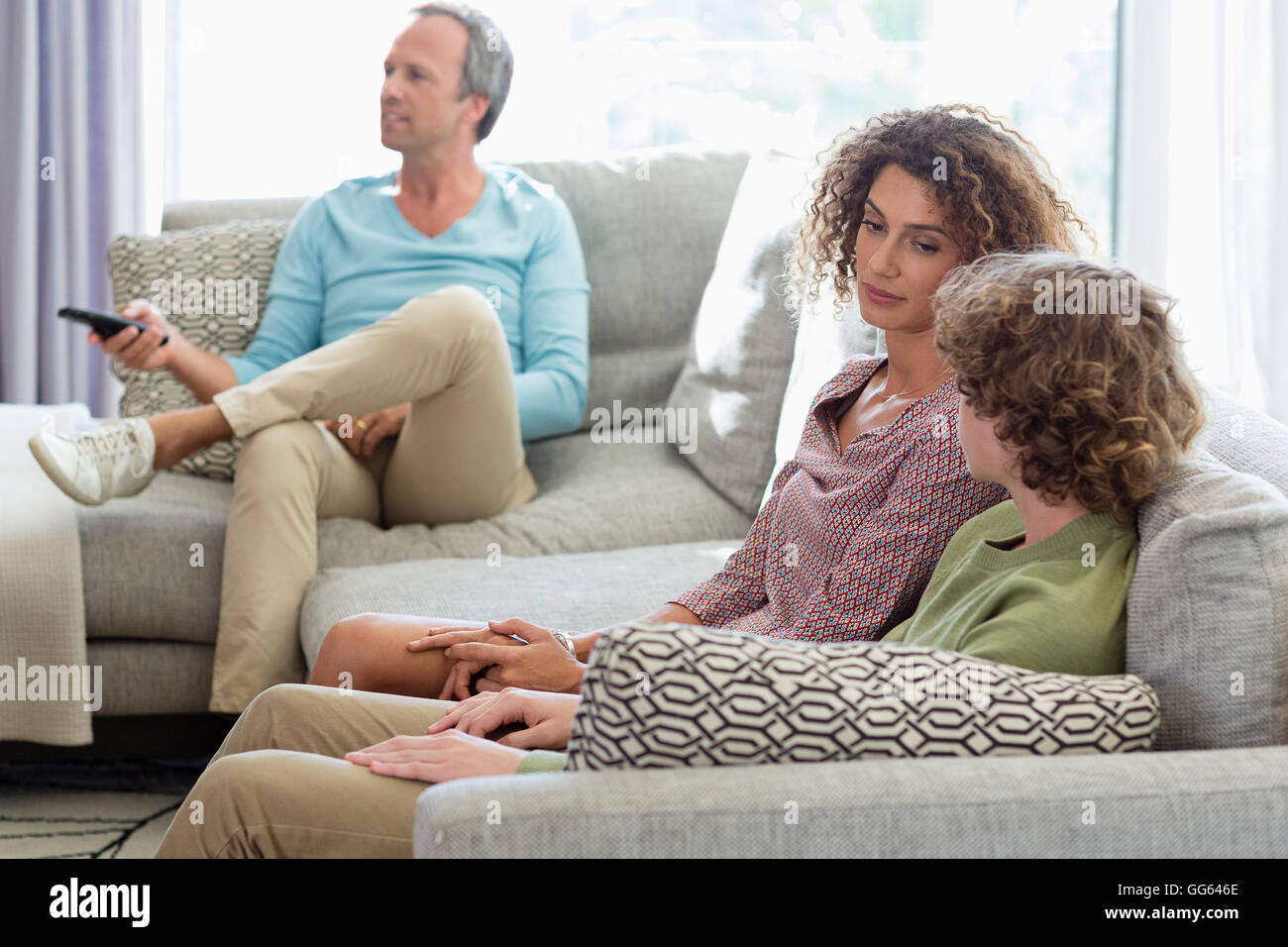 Happy family sitting in a living room at home Stock Photo - Alamy