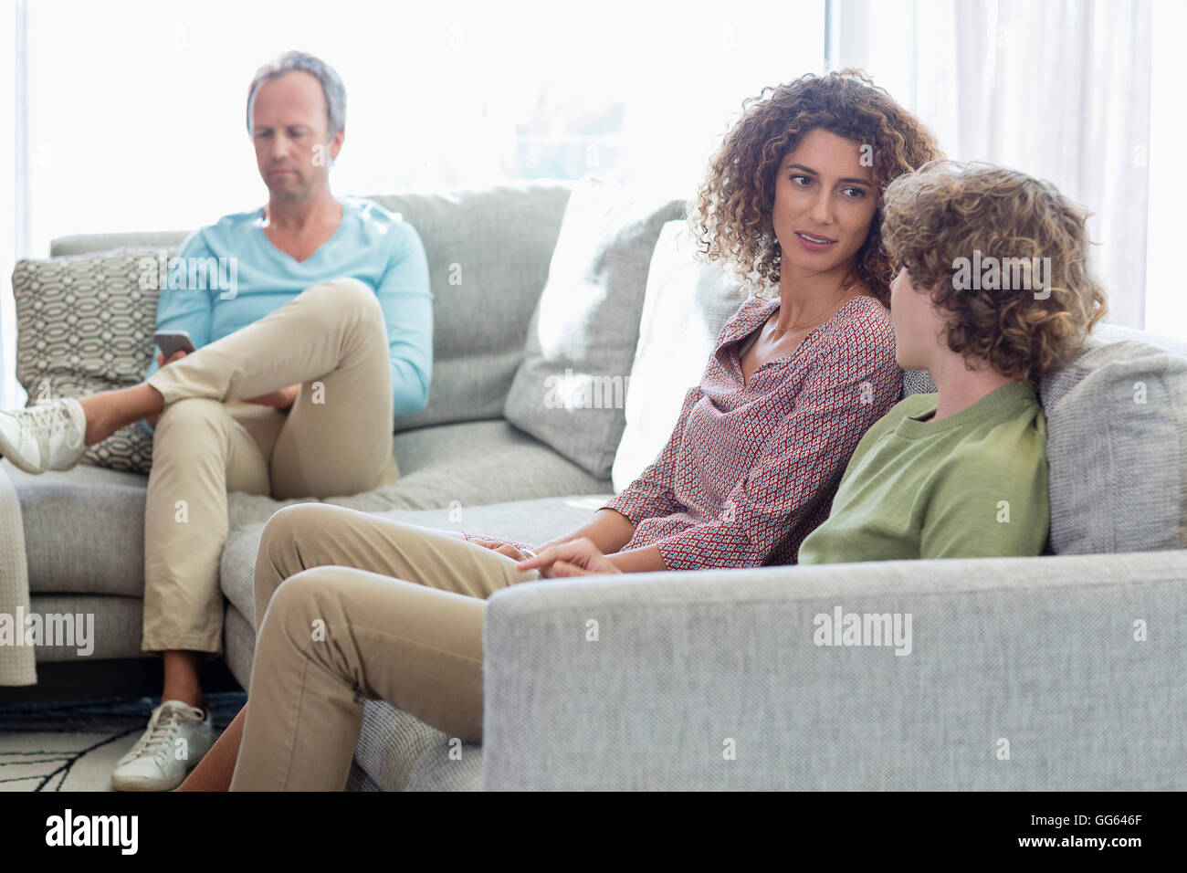 Happy family sitting in a living room at home Stock Photo - Alamy