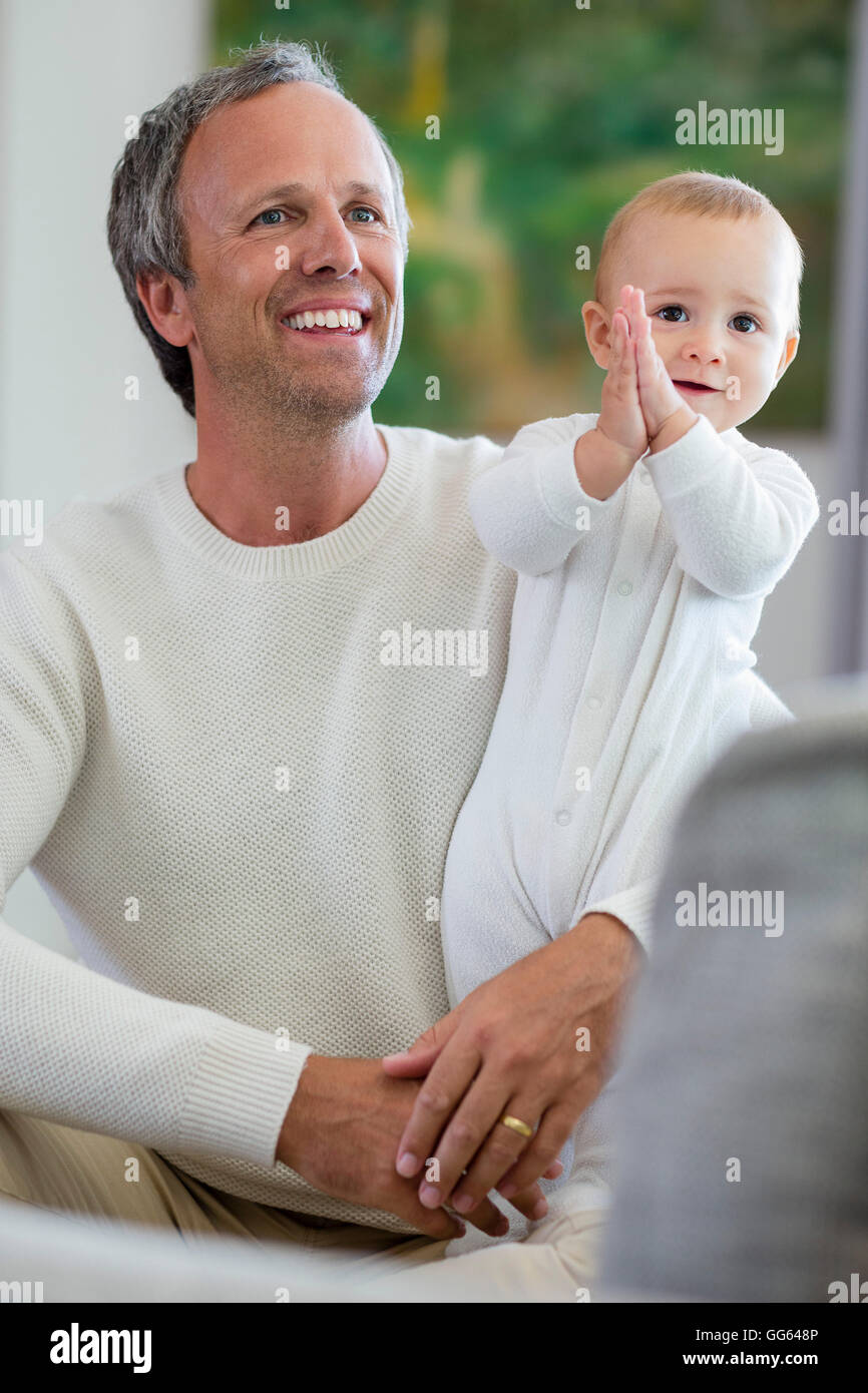 Happy father with his cute baby daughter in living room Stock Photo - Alamy