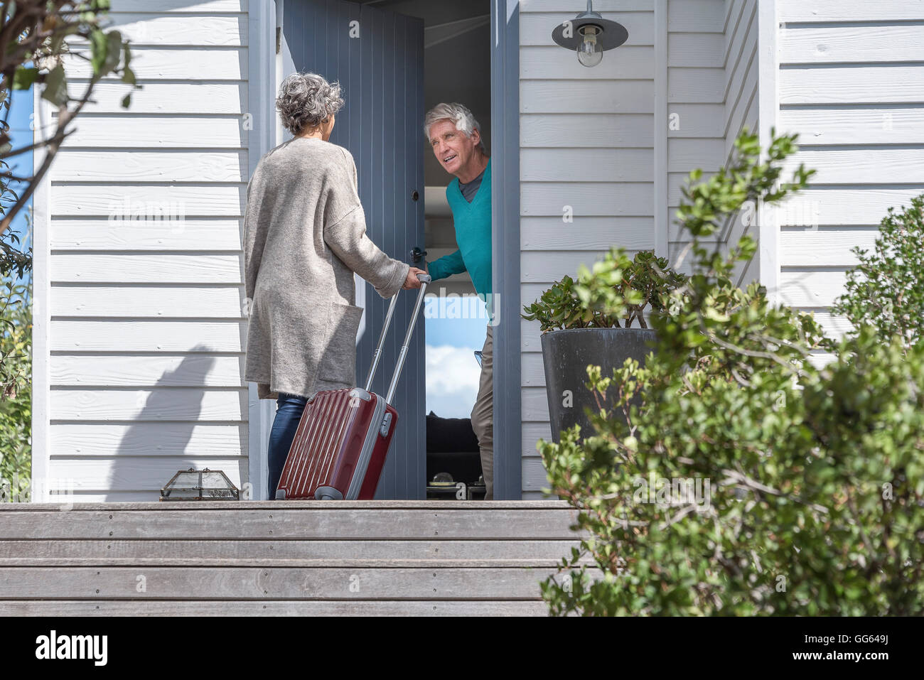 Woman welcoming man into the house hi-res stock photography and images ...