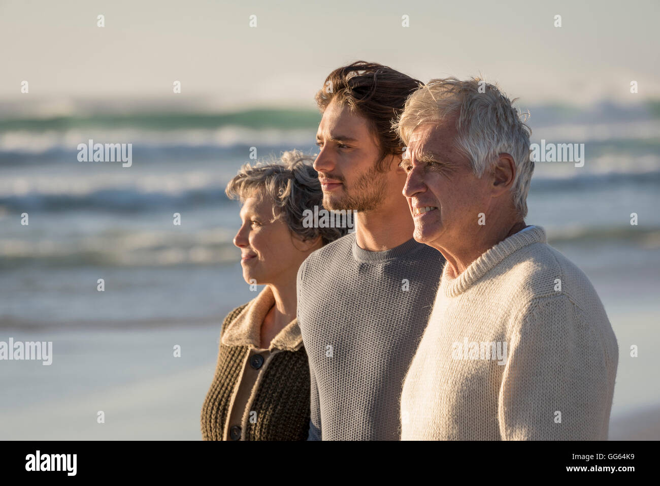 Happy family standing on the beach Stock Photo - Alamy