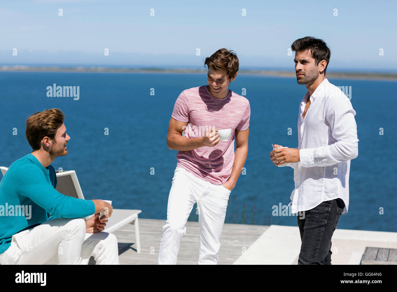 Three men drinking coffee at a resort Stock Photo - Alamy
