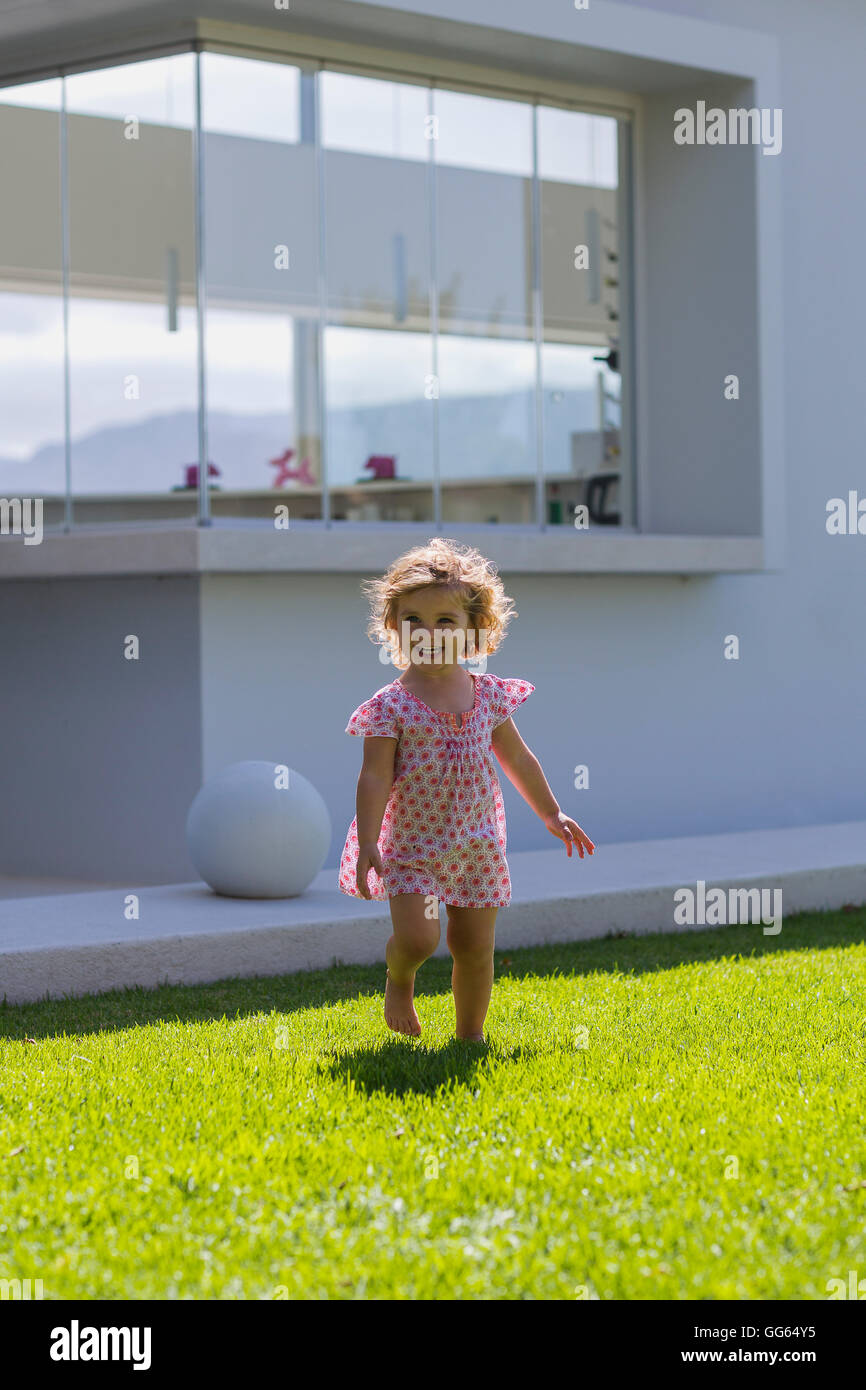 Baby girl playing in backyard of the house Stock Photo - Alamy