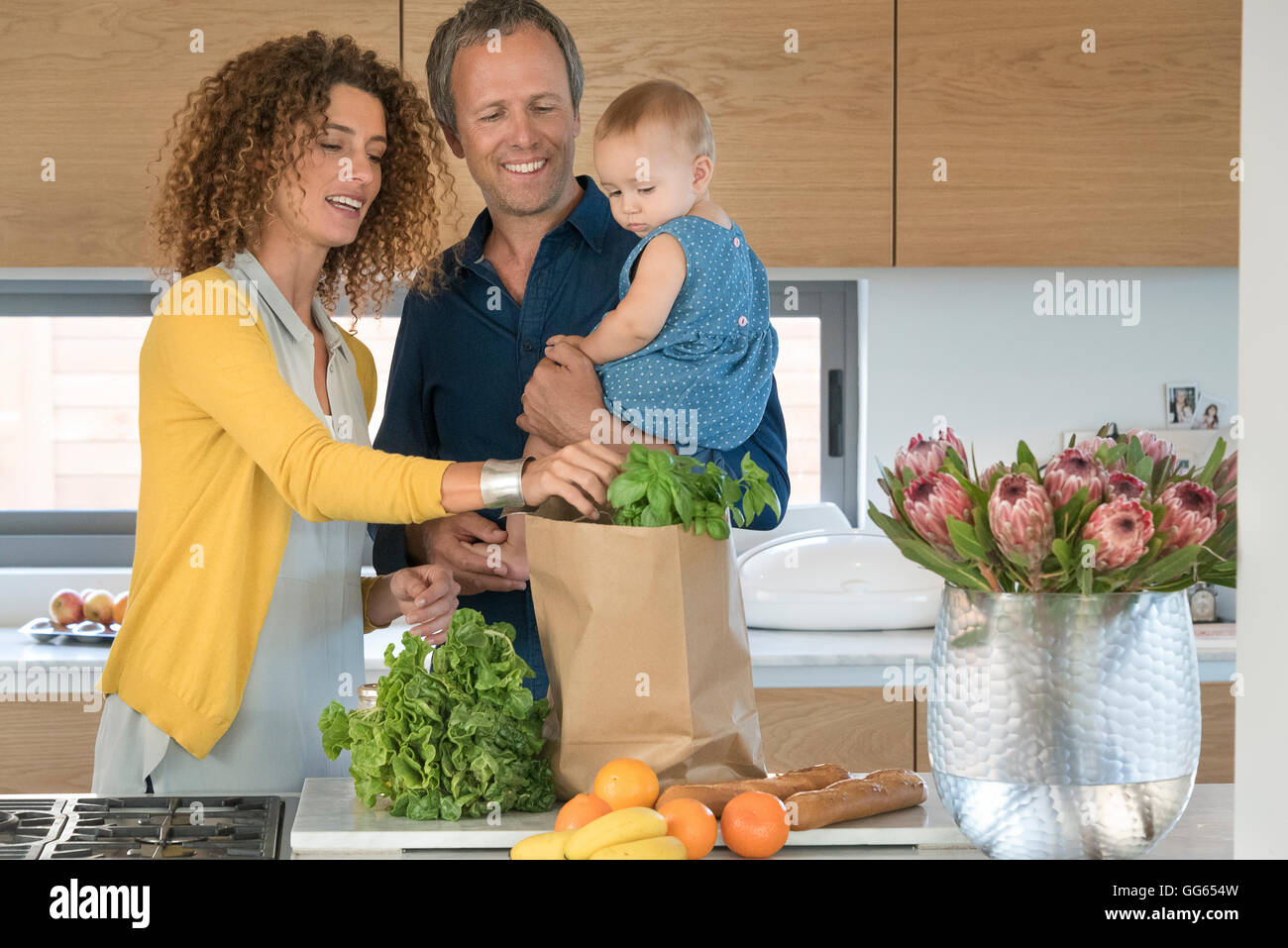 Family taking out food from paper bag in the kitchen Stock Photo - Alamy