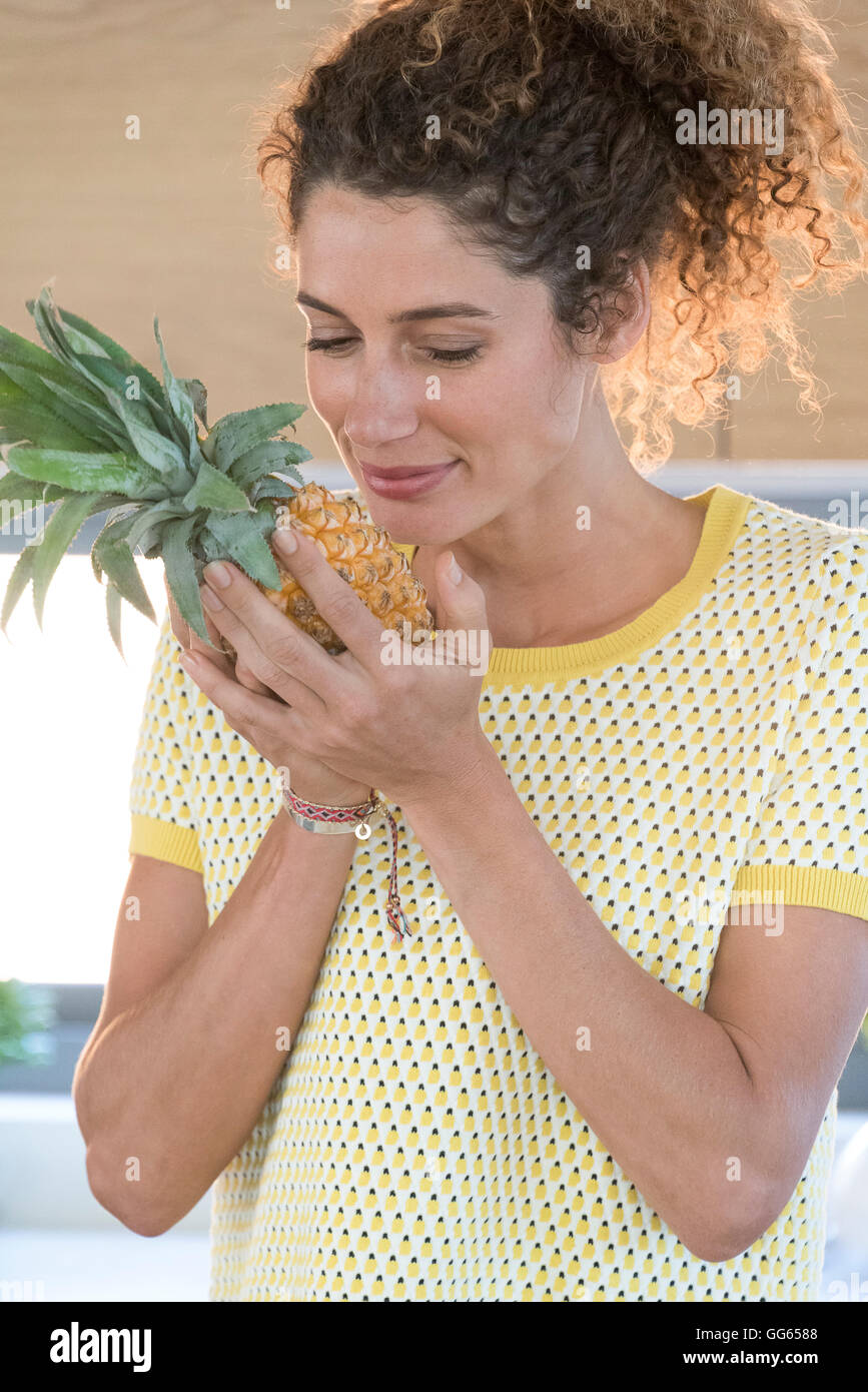 Close-up of a woman smelling a pineapple Stock Photo - Alamy