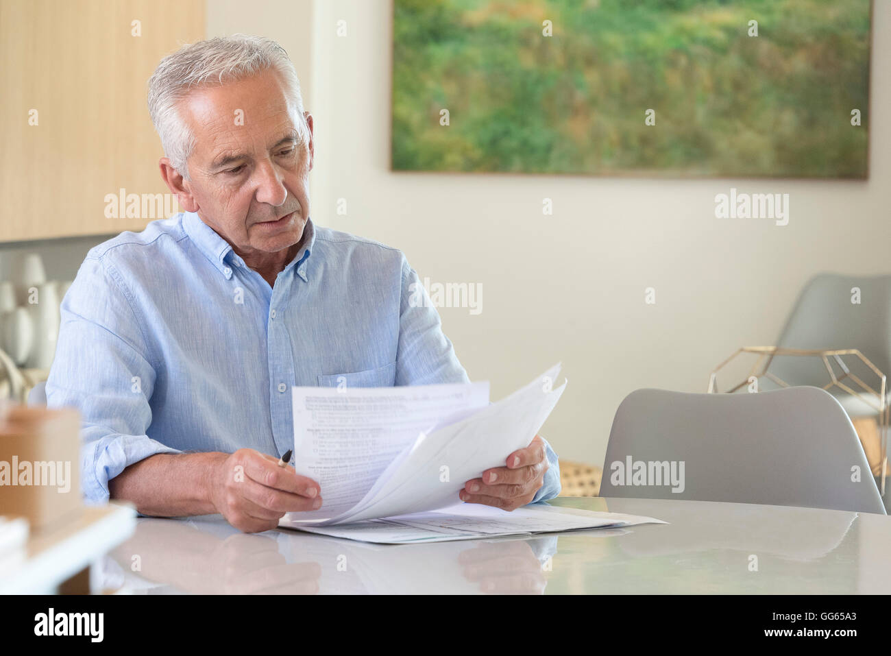 Senior man doing paperwork at home Stock Photo - Alamy
