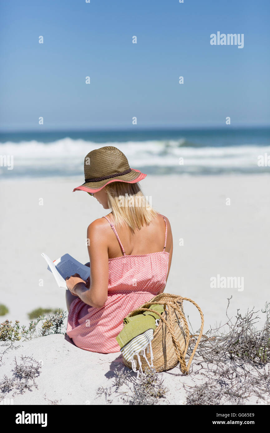 Woman reading a book o the beach Stock Photo - Alamy