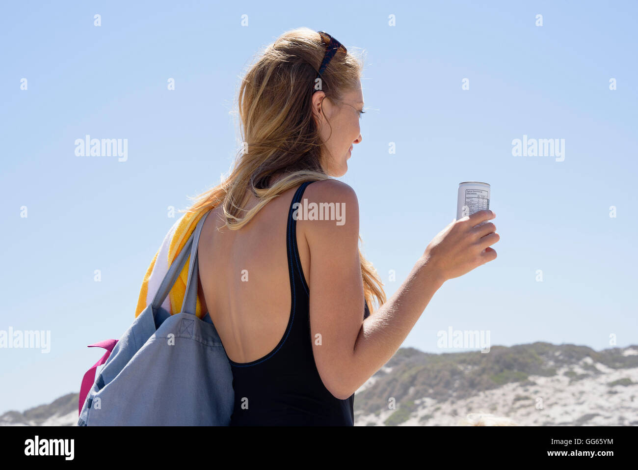 Beautiful woman enjoying cold drink on beach Stock Photo - Alamy