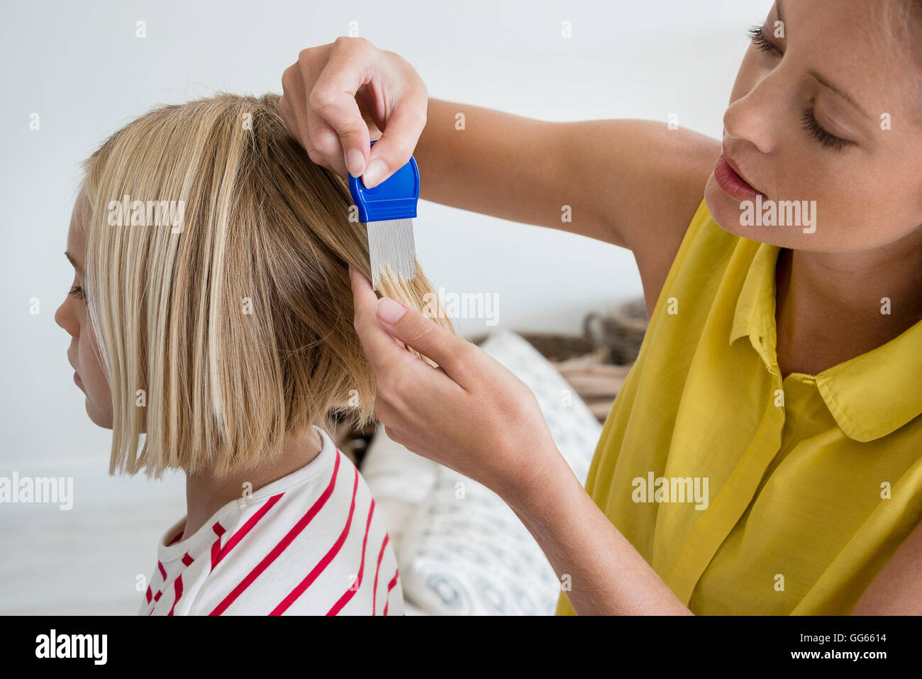 Mother using lice comb on daughter's hair Stock Photo - Alamy