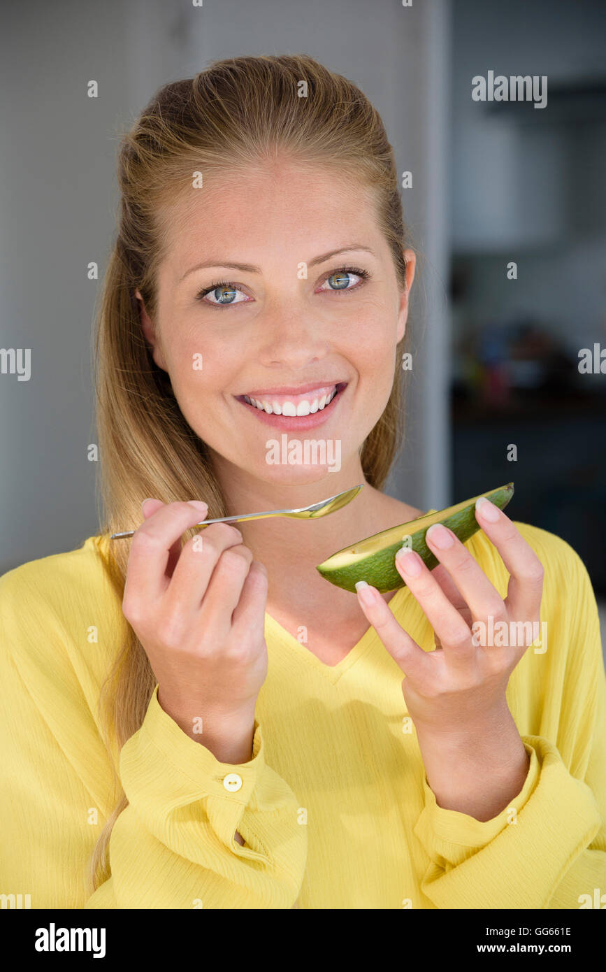 Portrait of a happy beautiful woman eating avocado Stock Photo - Alamy
