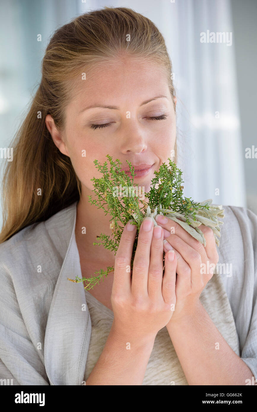 Beautiful woman smelling fresh aroma herbs Stock Photo - Alamy