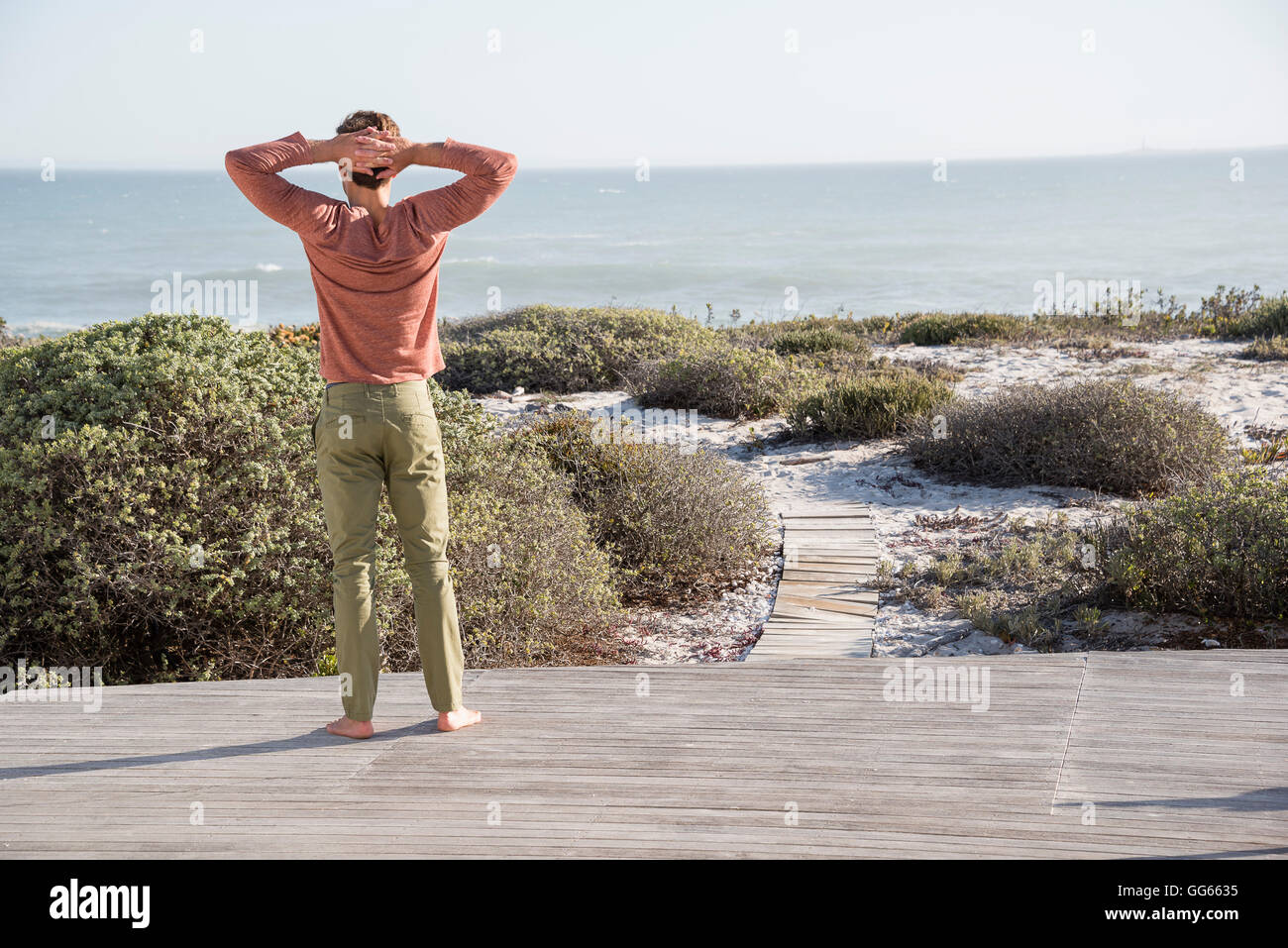 Young man looking at sea on the beach Stock Photo - Alamy
