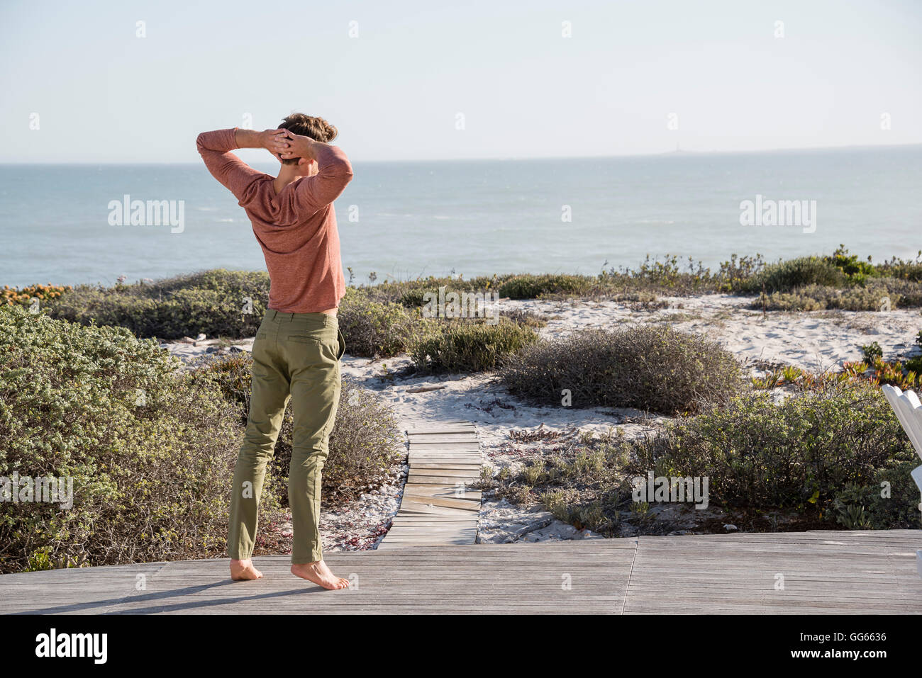 Young man looking at sea on the beach Stock Photo - Alamy