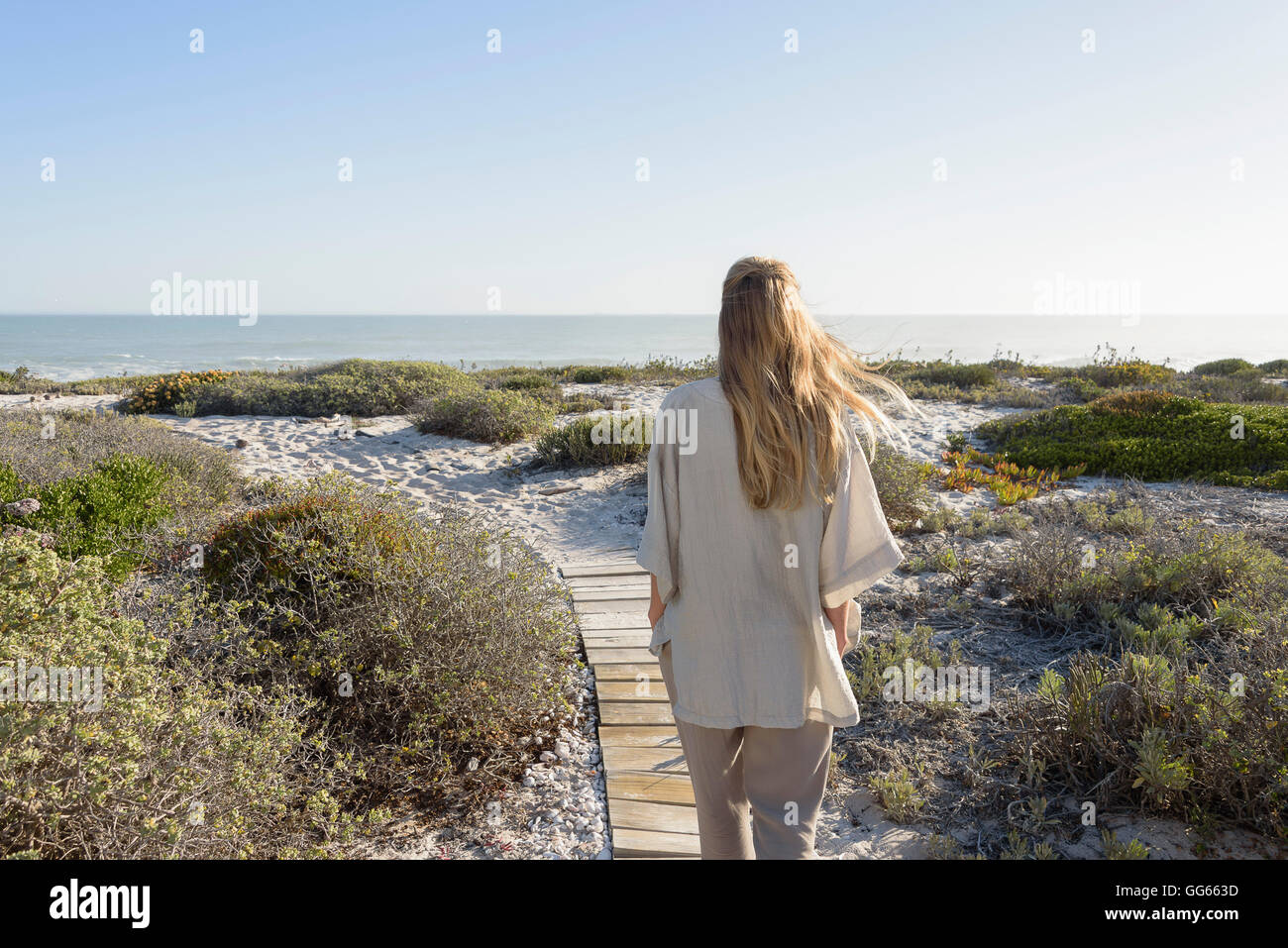 Rear view of a woman walking on the beach Stock Photo - Alamy