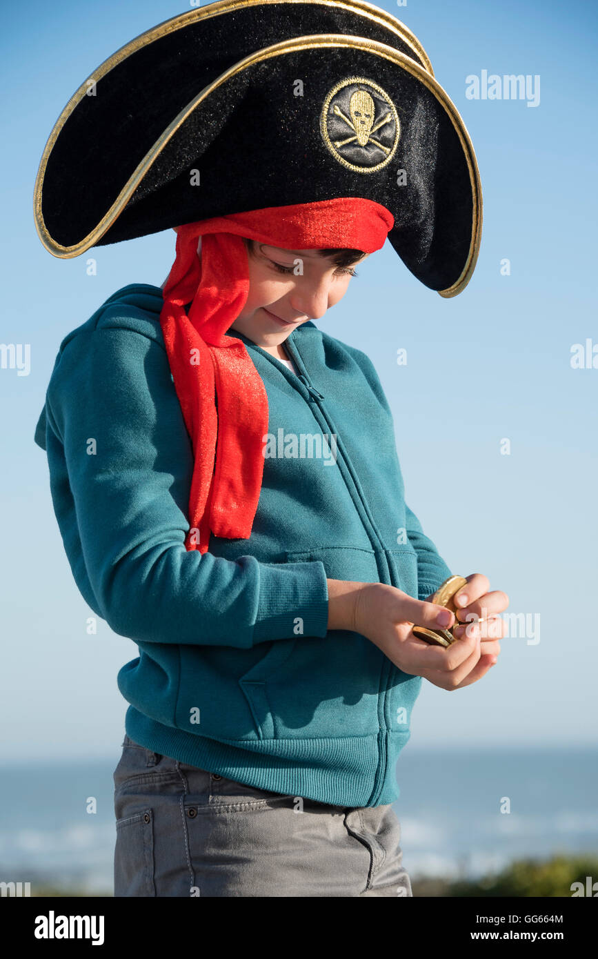 Pirate little boy holding coins Stock Photo - Alamy