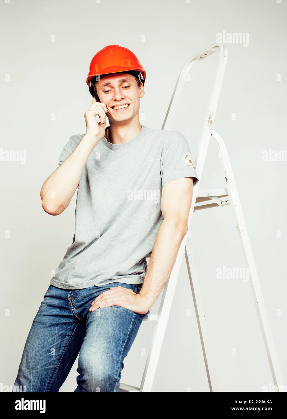 young real hard worker man isolated on white background on ladder ...