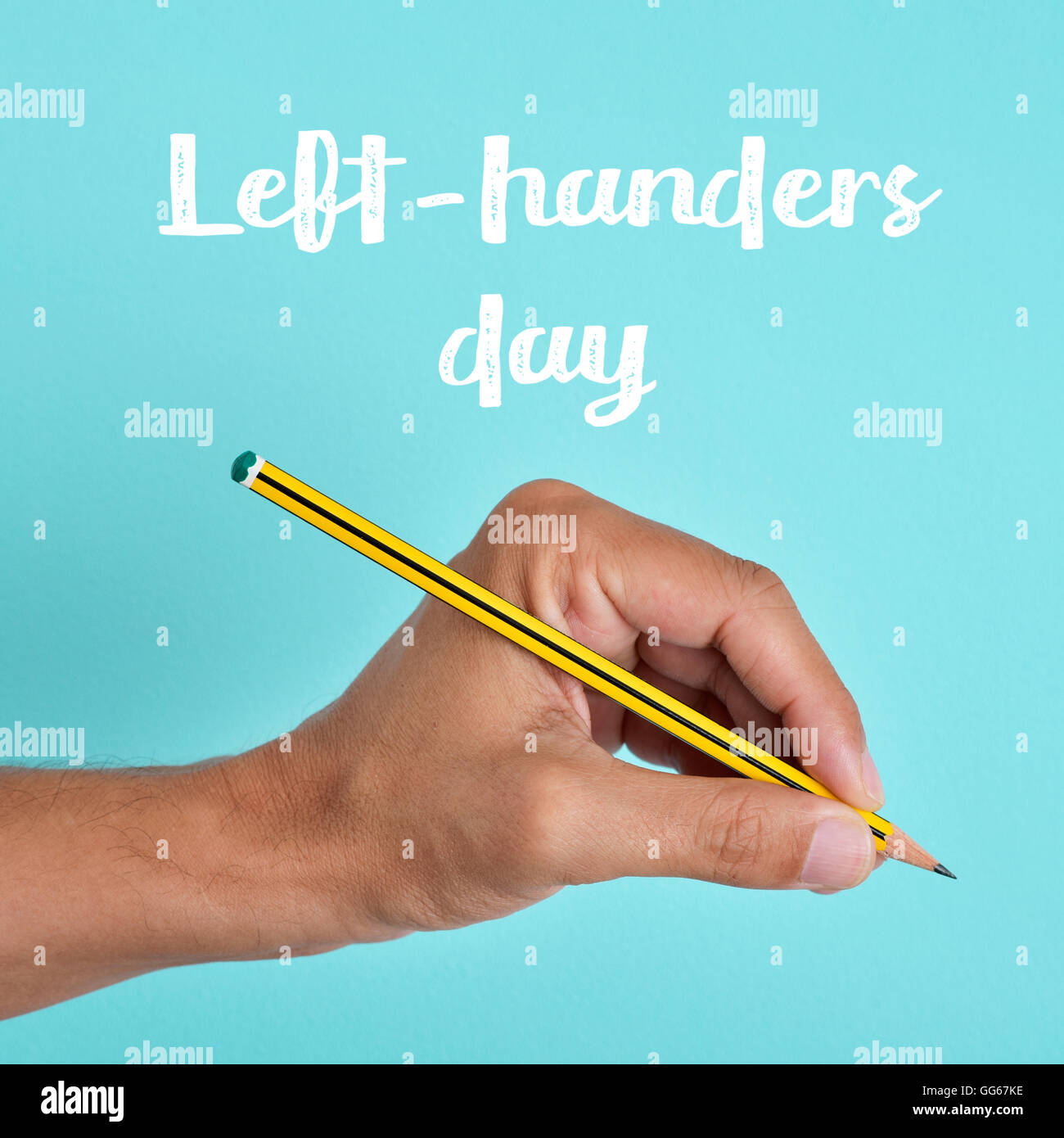 the text left-handers day and the hand of a left-handed man with a ...