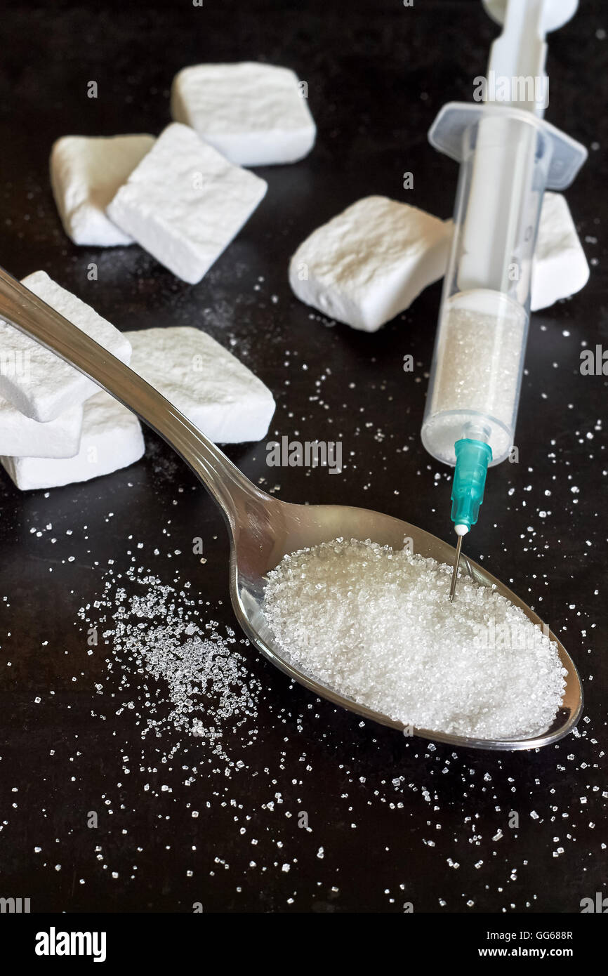 Injection with needle filled with sugar on black rustic background ...