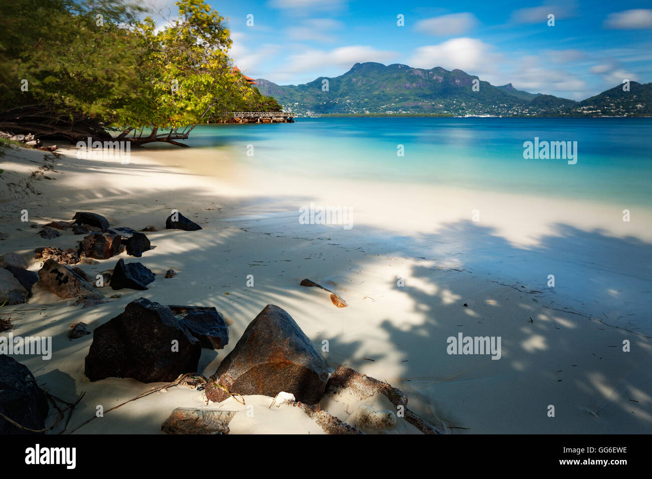 A deserted Seychelles beach with the calm still waters of the Indian ...