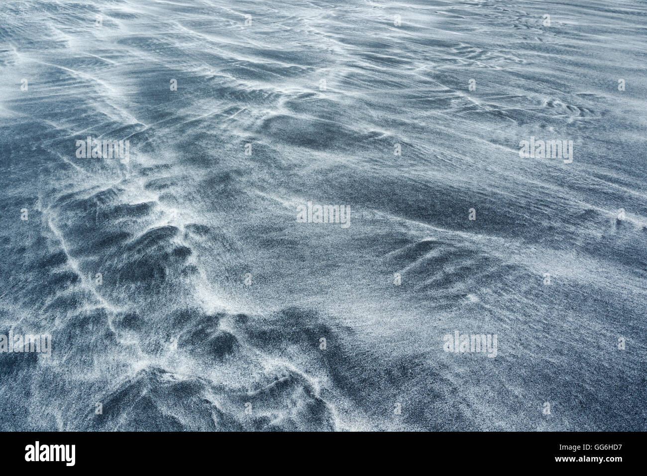 Patterns formed by tidal movements of black volcanic sand and white ...