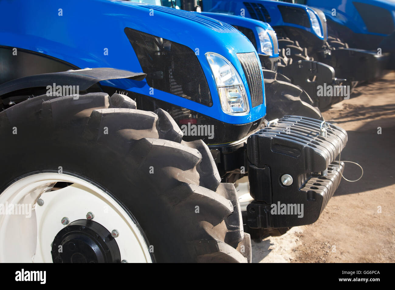 Close up of blue modern tractors on a row Stock Photo - Alamy