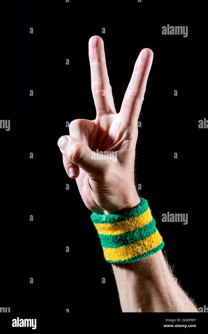 Hand of athlete with Brazil colors wristband holding up peace sign ...