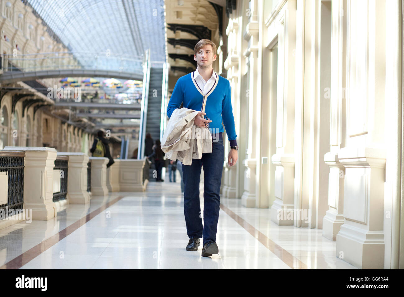 Young man walking in the store Stock Photo - Alamy