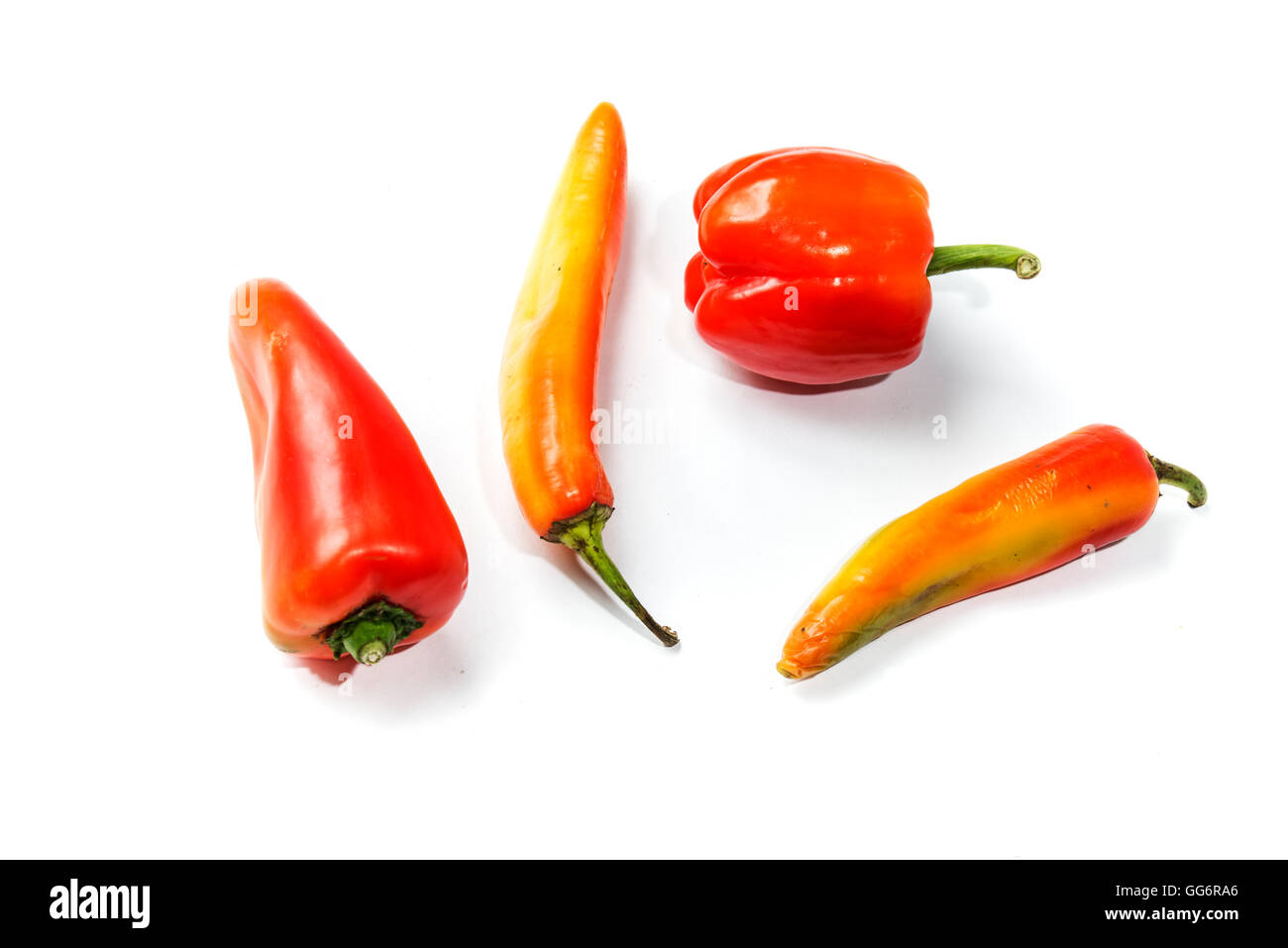 four red peppers of different shapes on white background Stock Photo ...