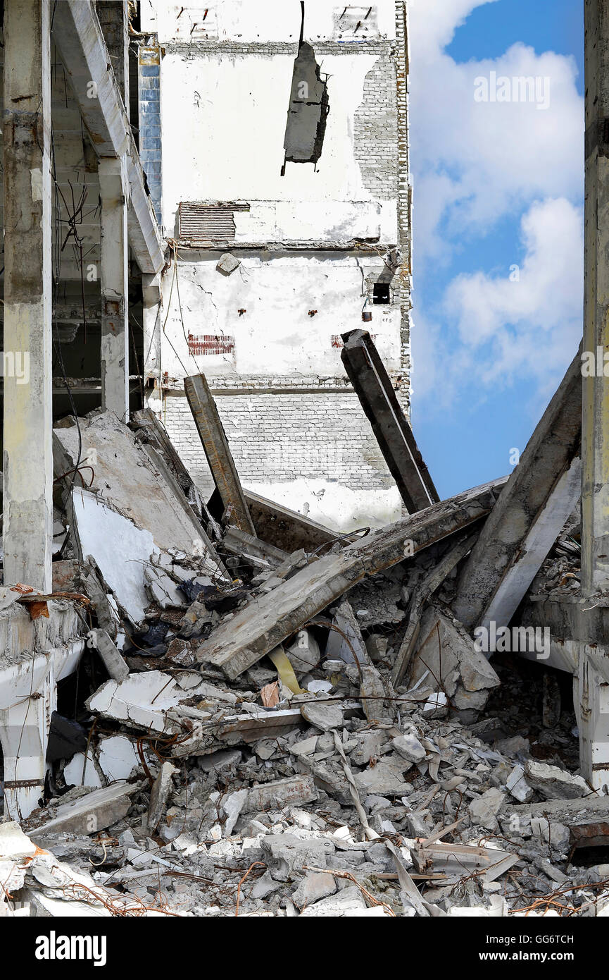 Chunks of concrete and metal on a background of a wall of the destroyed ...