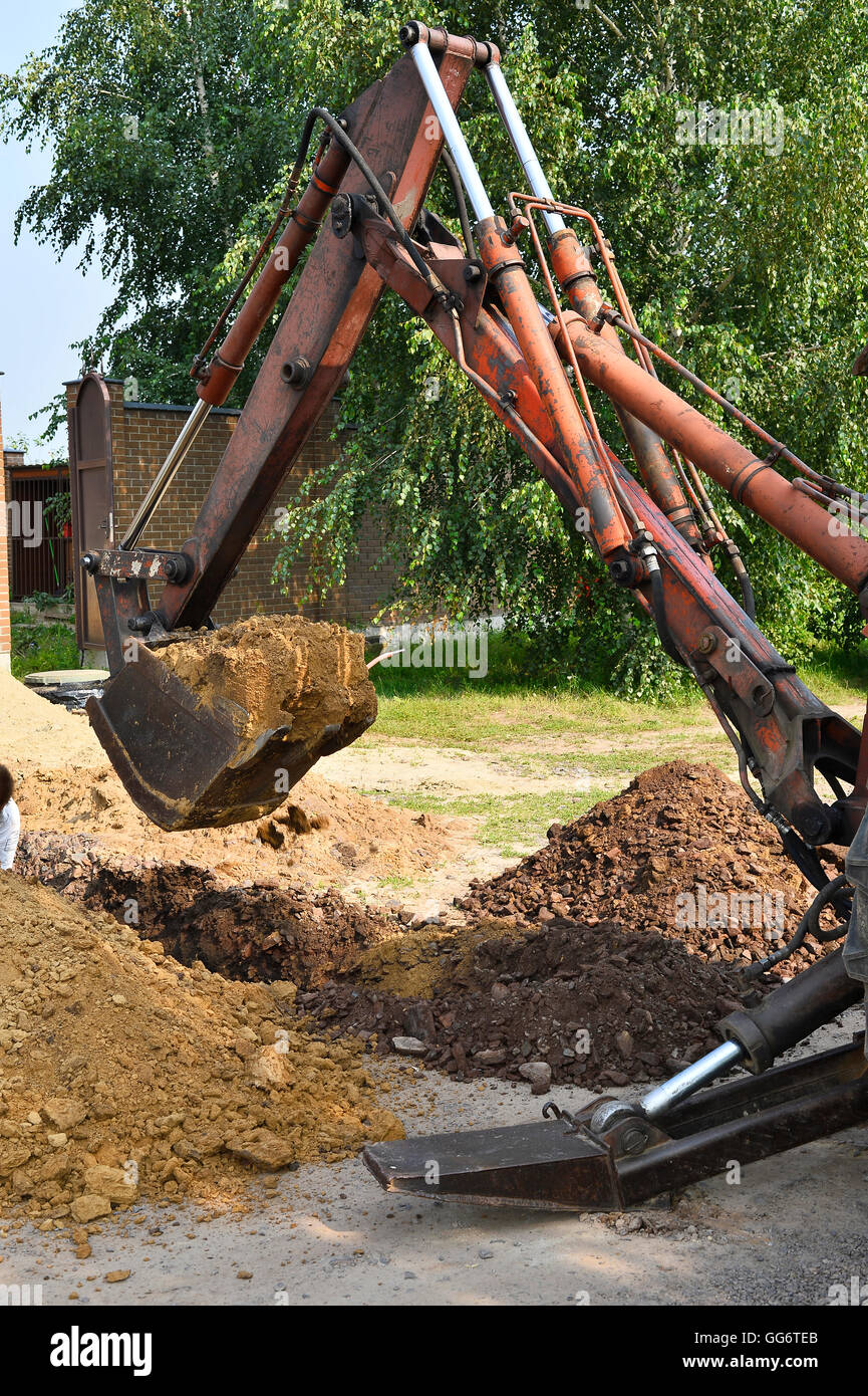 Excavator bucket digging a trench in the dirt ground Stock Photo - Alamy