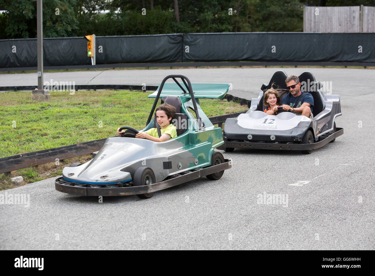 A man and children ride go-carts Stock Photo - Alamy