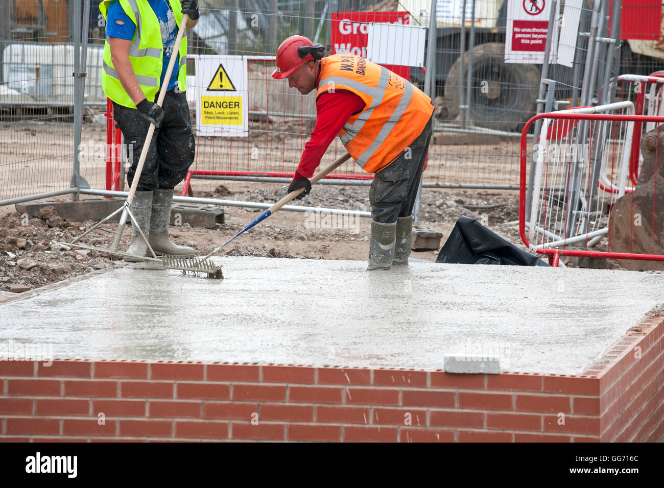Workmen applying Concrete bases being filled for new build housing ...