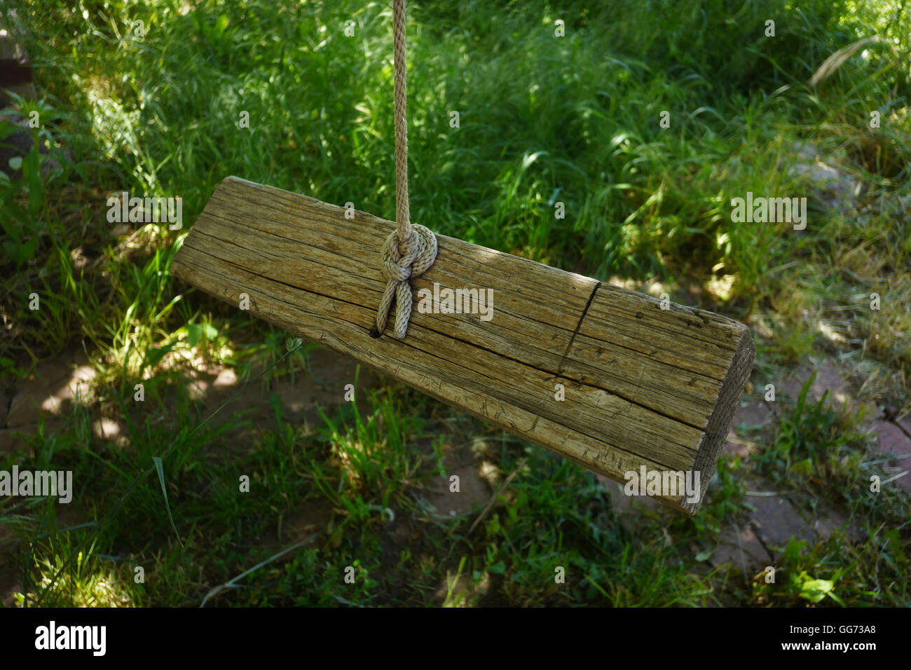 Weathered wooden rope swing hanging over unlandscaped ground Stock ...