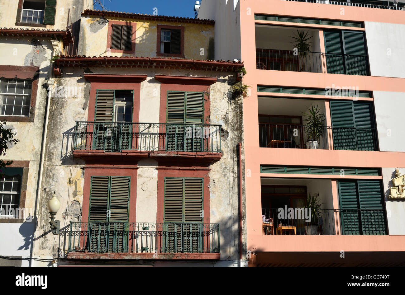 Disused and run down building between modern apartment blocks in ...