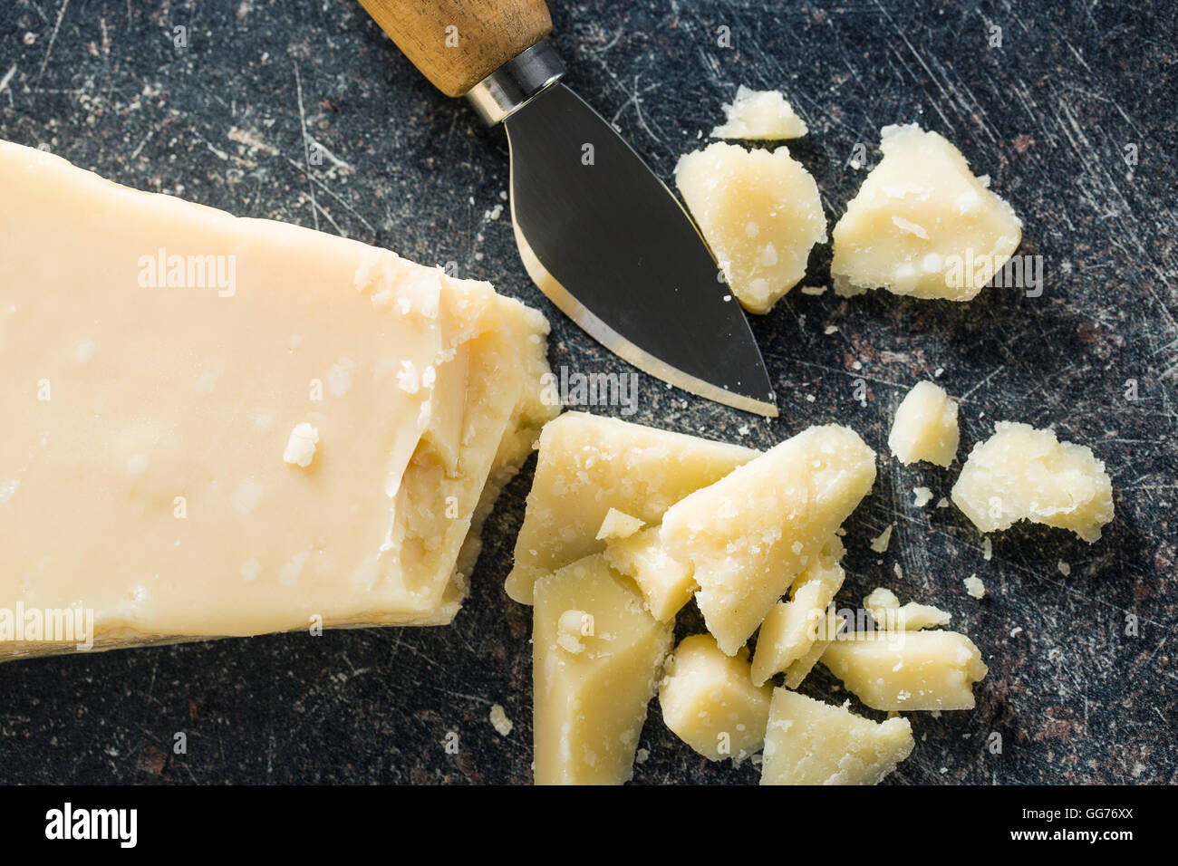 The parmesan cheese with knife on old kitchen table Stock Photo - Alamy