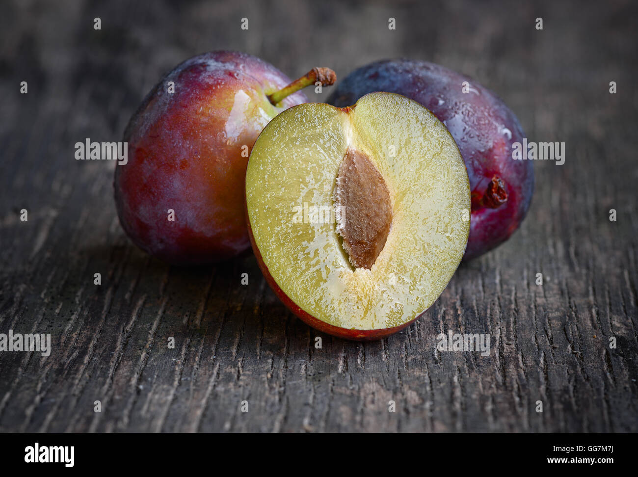 Fresh ripe plum on a wooden background Stock Photo - Alamy