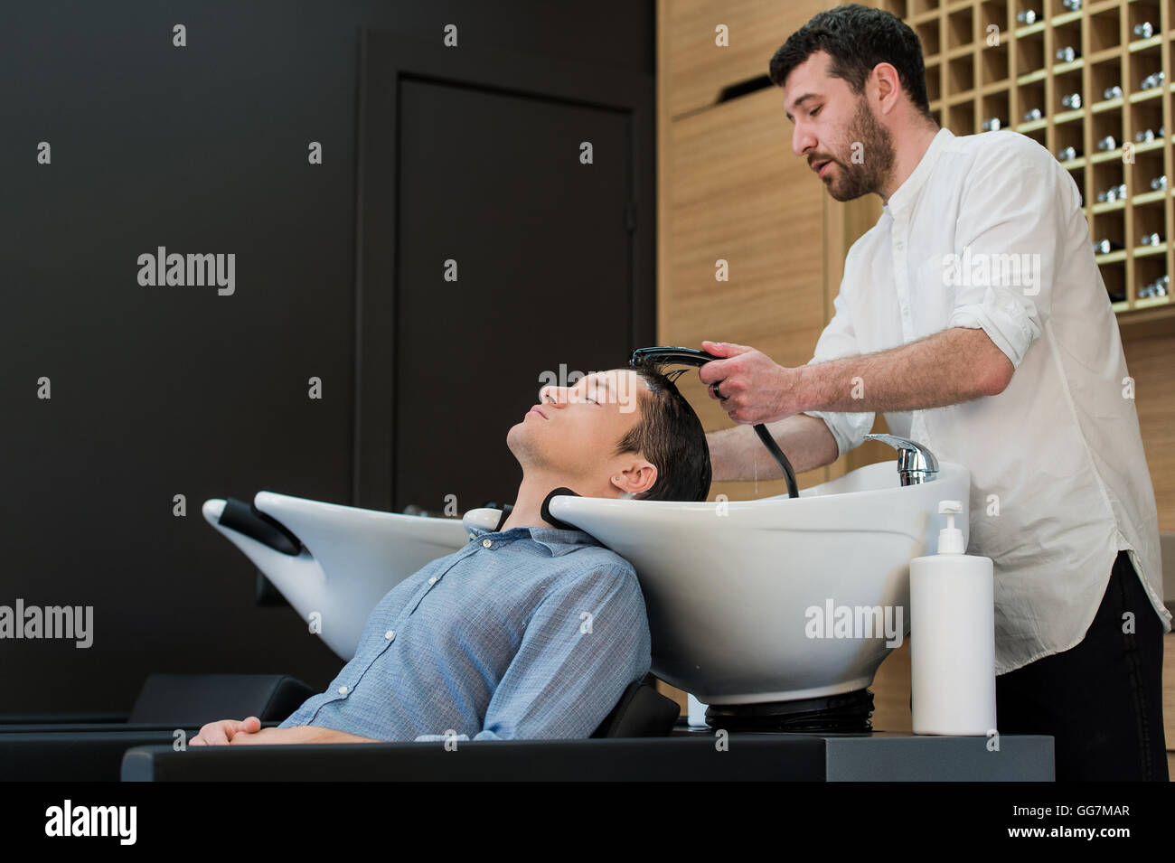 Young man at hairdresser salon getting his hair washed Stock Photo - Alamy