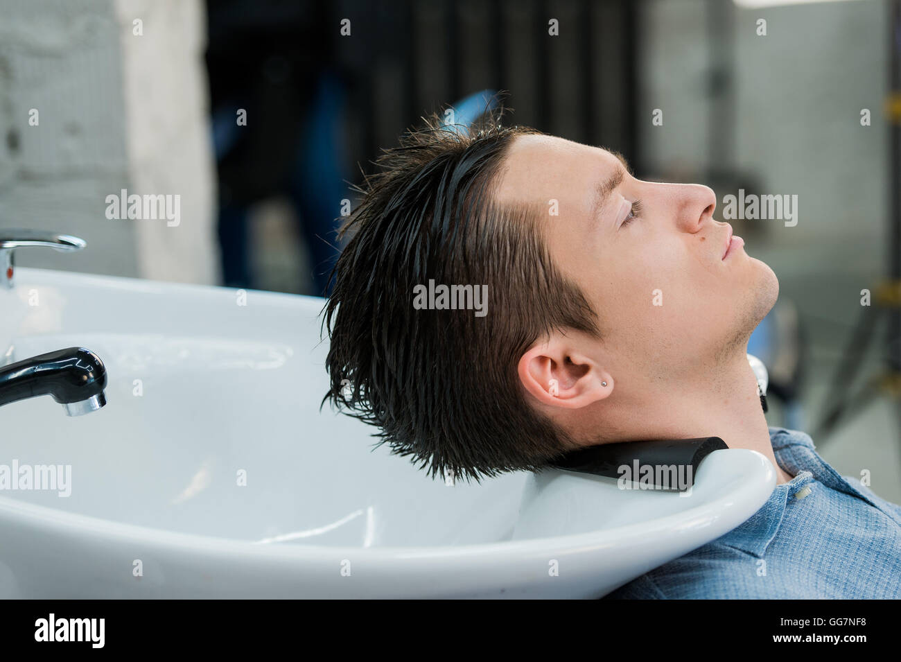 Profile view of a young man getting ready for his hair washed Stock ...