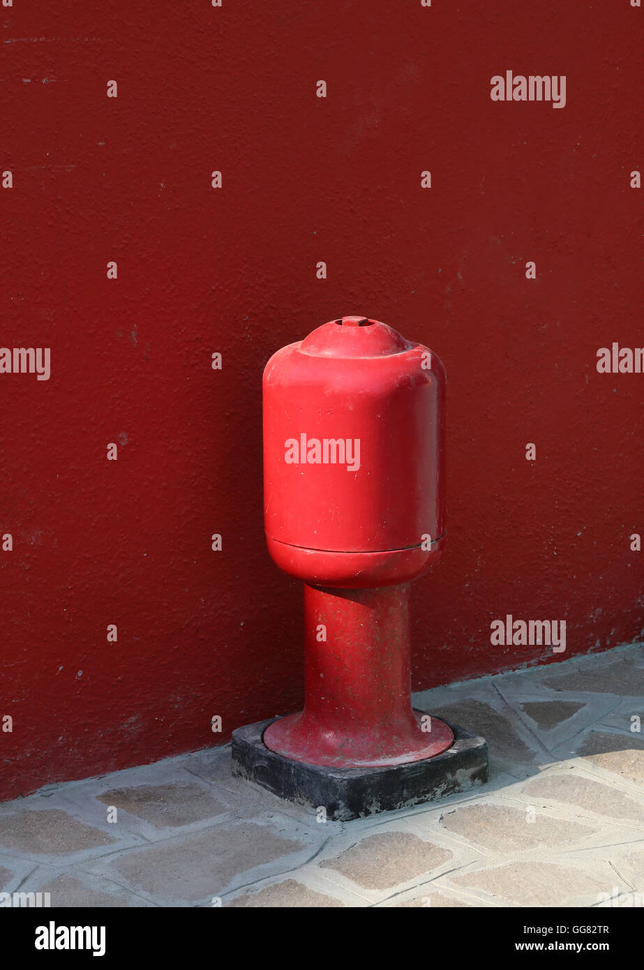 big red fire hydrant on a background of Red Wall of House Stock Photo ...
