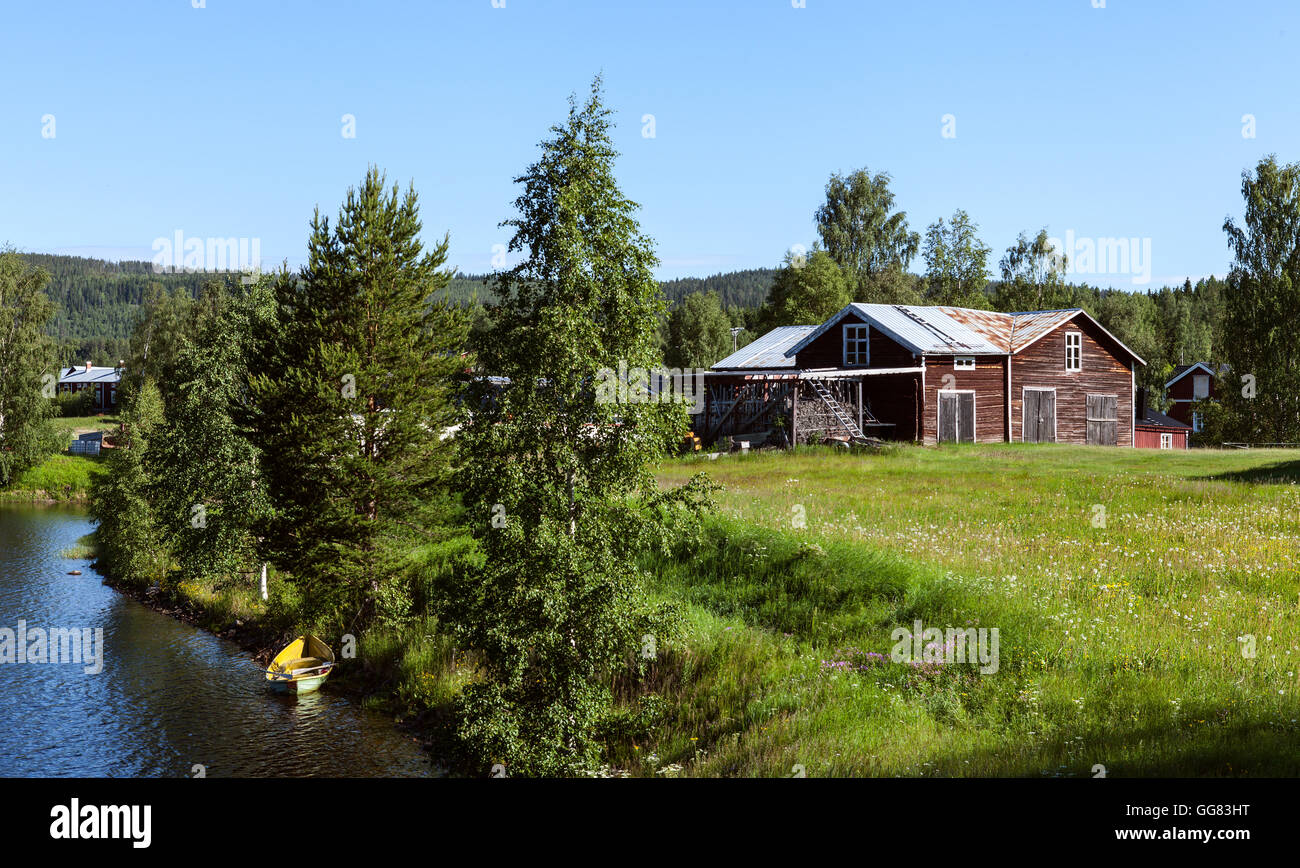 Old wooden building on the riverside. Sunny morning in June in rural ...