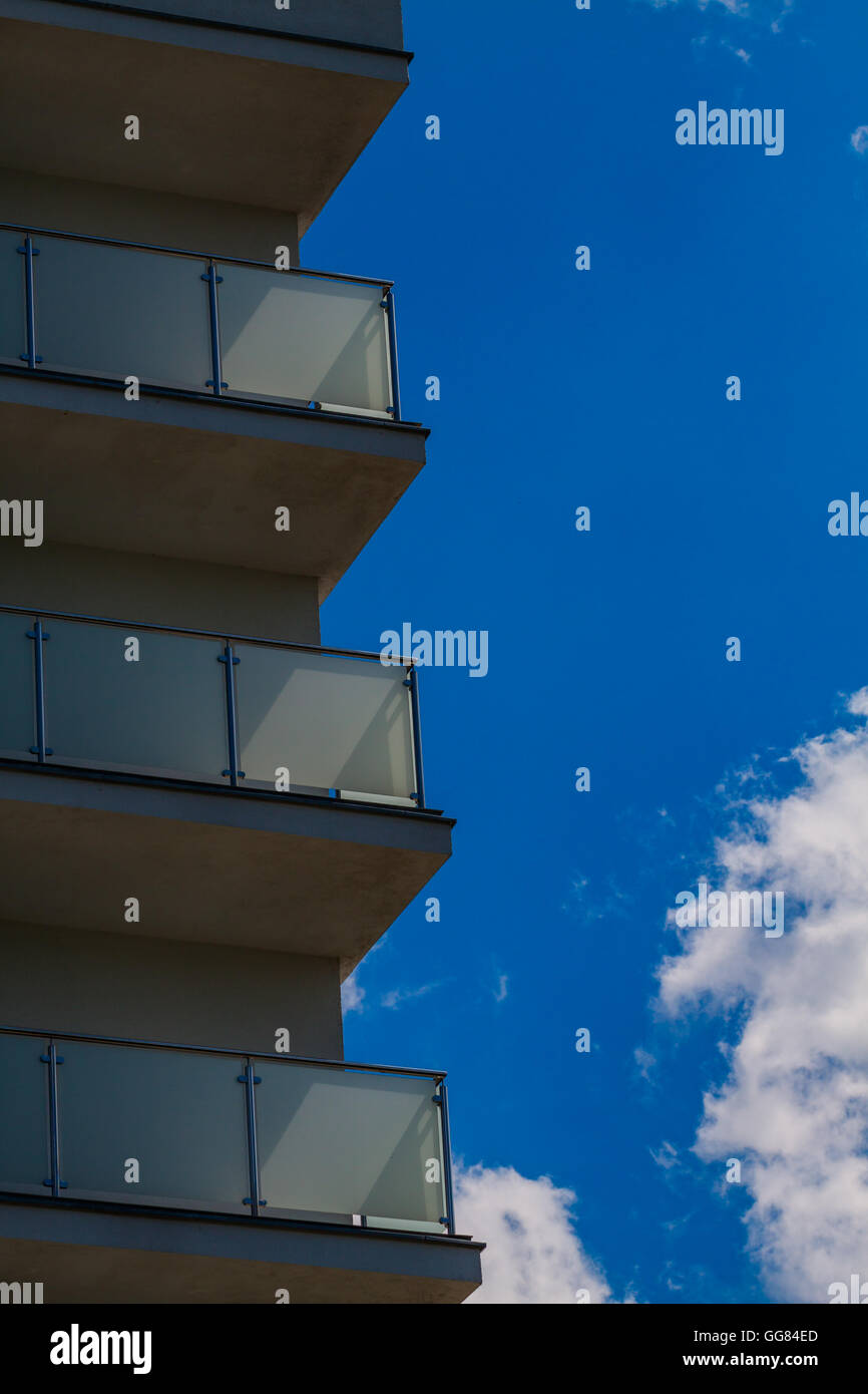 Glass balcony barrier in corner of apartment building exterior in ...
