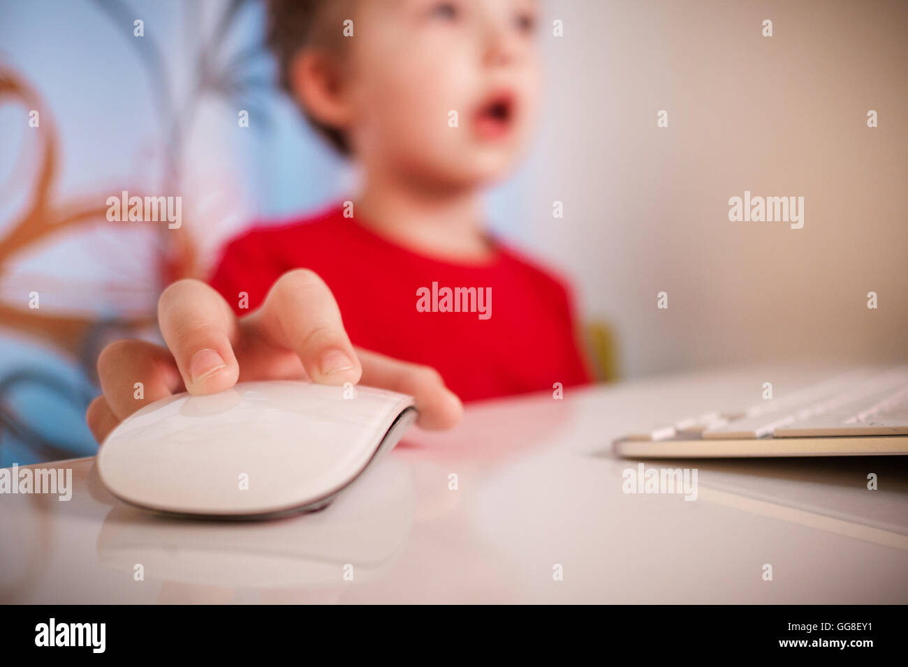 closeup view of young boy playing with computer at night lit by the ...