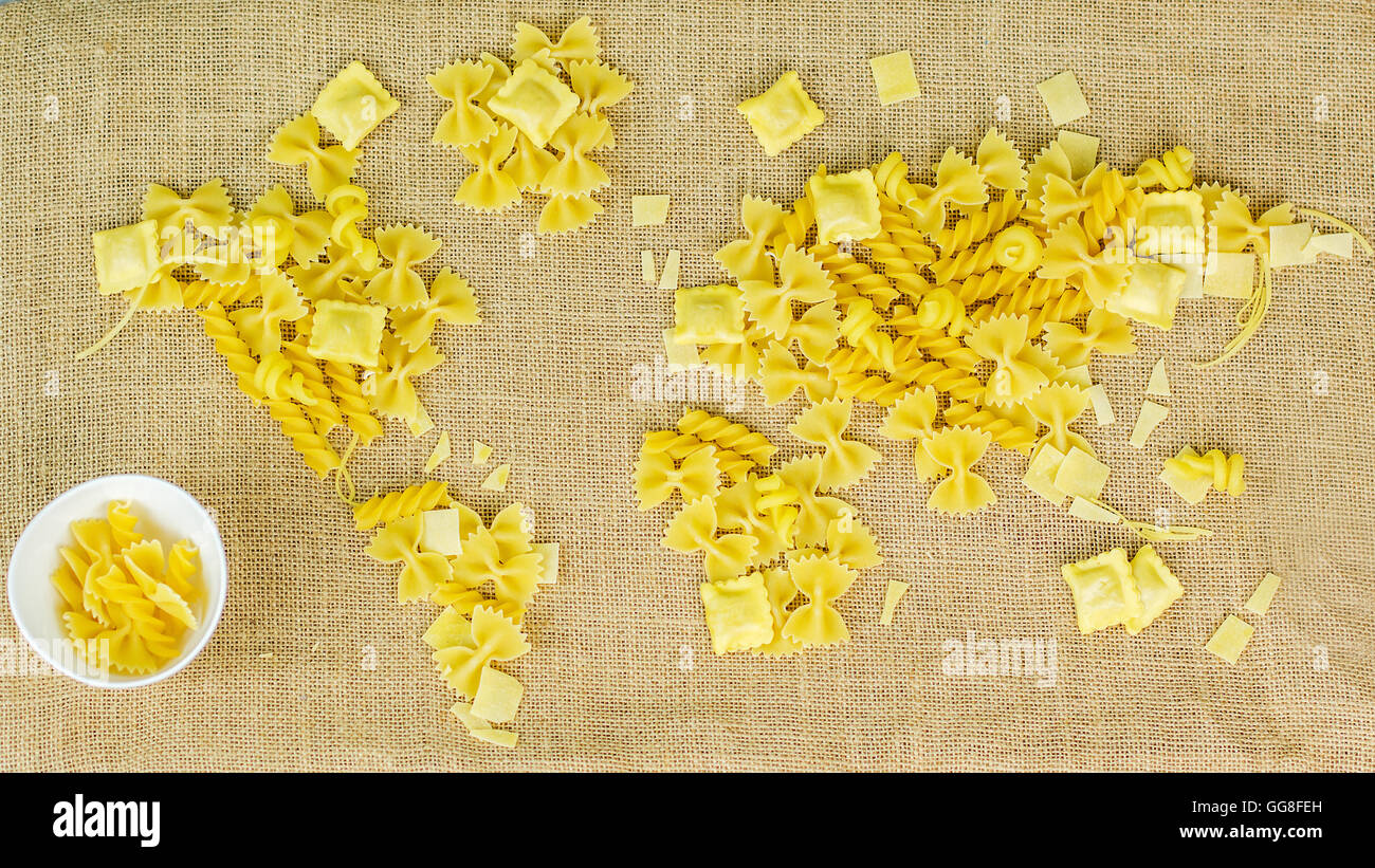 map of the world made of raw pasta on brown fabric background with ...