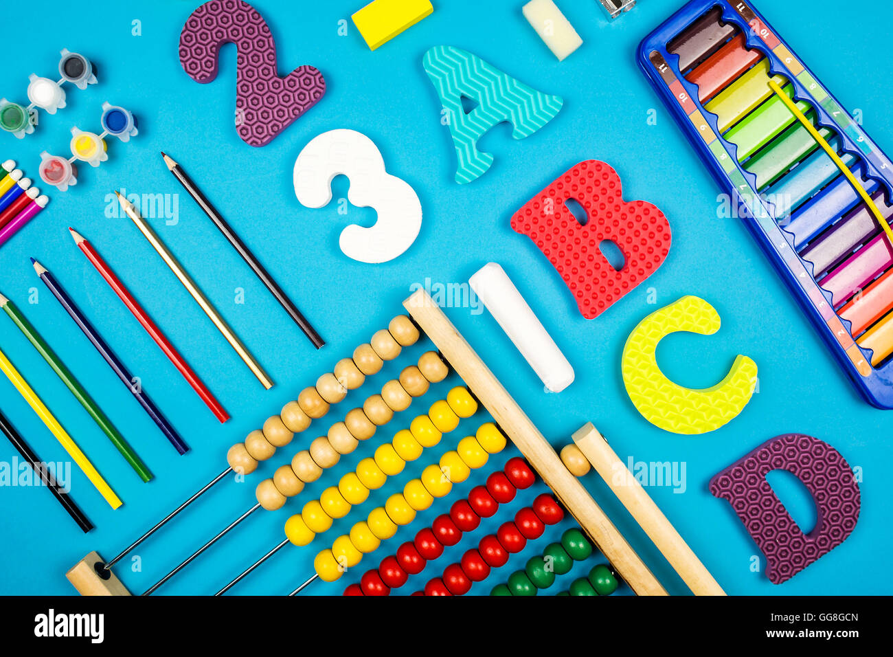multiple preschool and school tools laying on turquoise background ...