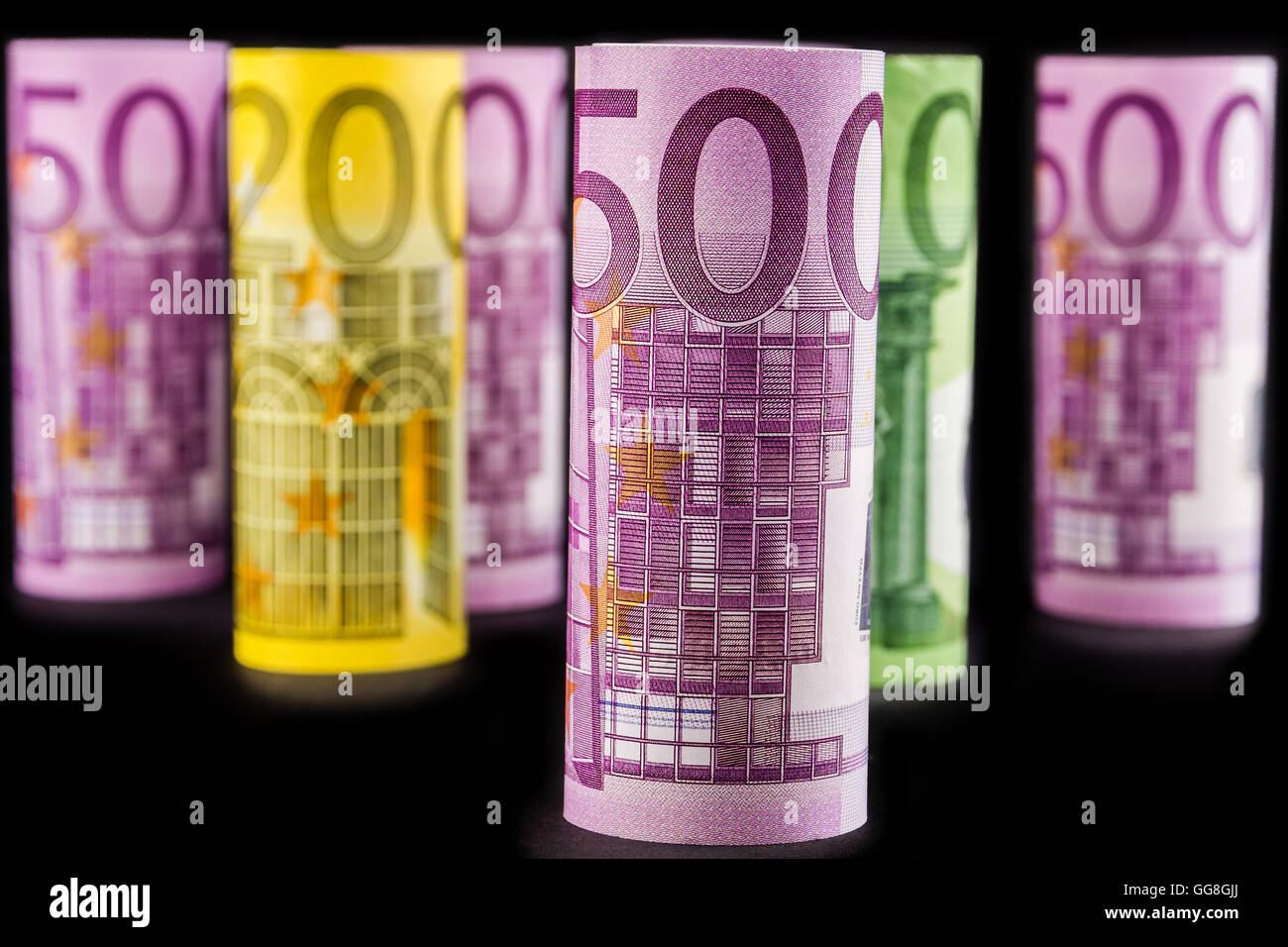 500 euro rolled banknote with the background made of euro banknotes ...