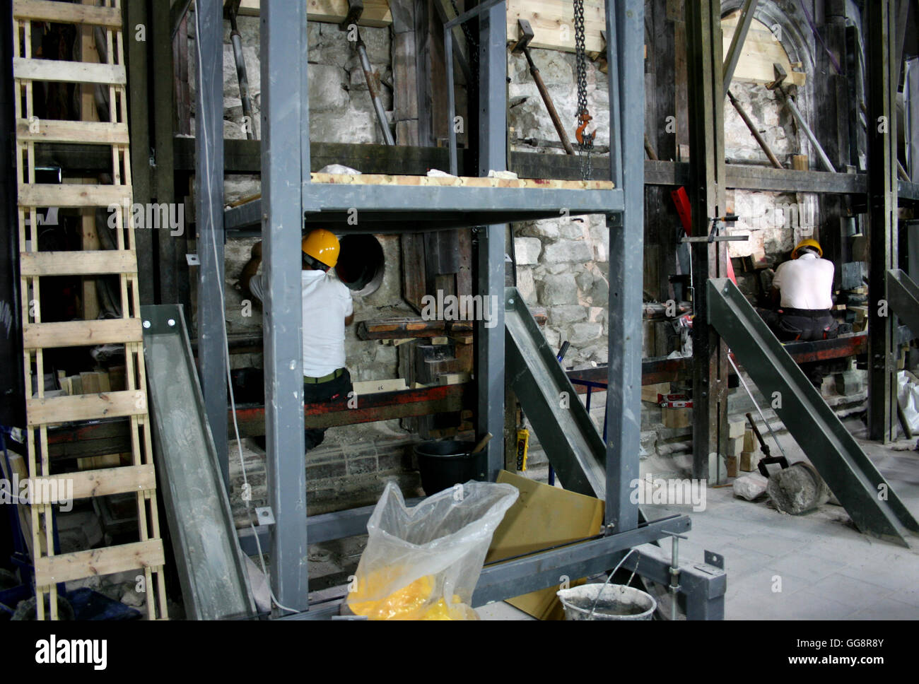 Construction workers work with hammers and chisels on the stones of the ...